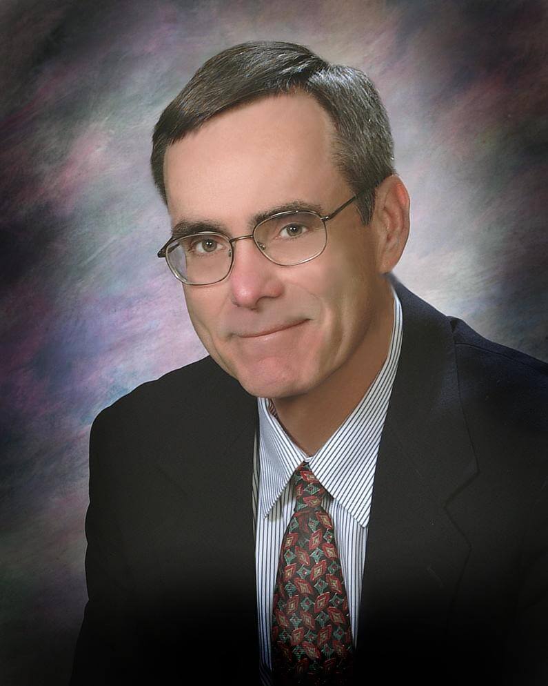 Man in a suit and tie smiling. - Faulkner Society